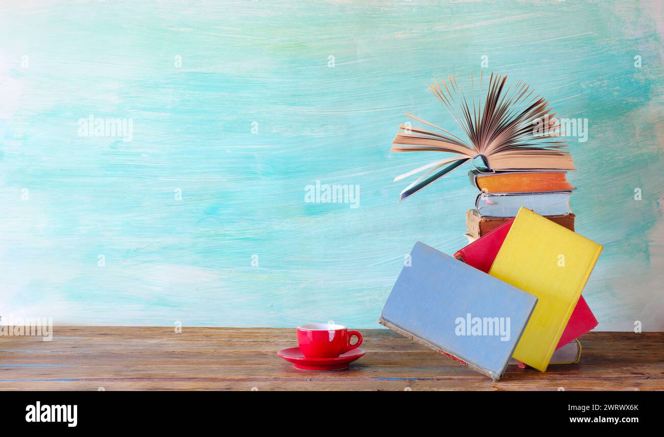 Stack of books with open book and cup of espresso coffee, reading ...