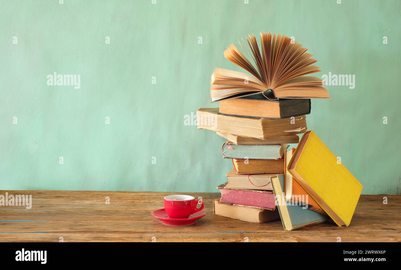 Stack of books with open book and cup of espresso coffee, reading ...