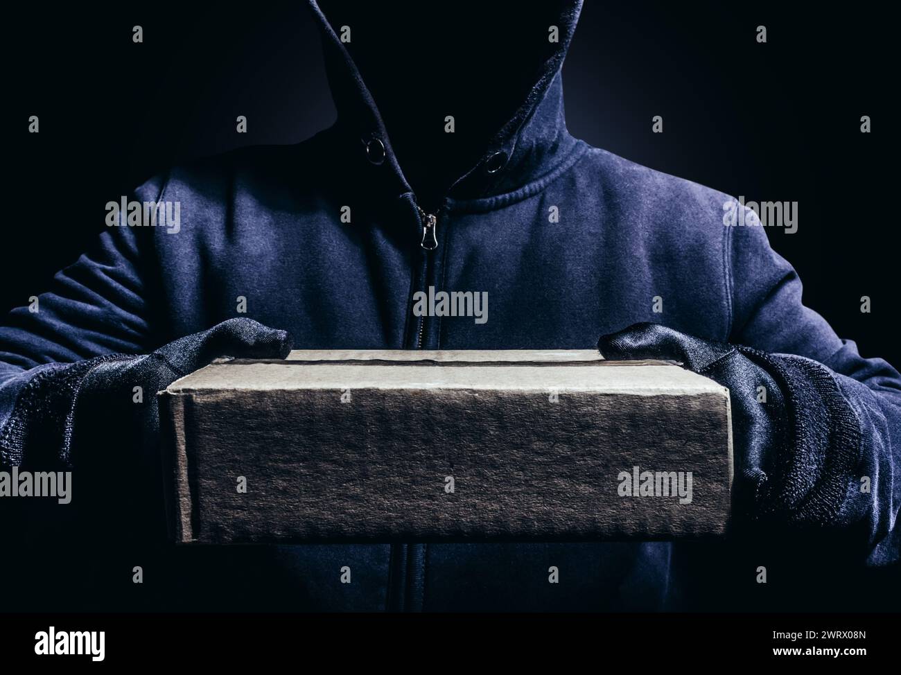 Photo of scary shaded hooded man giving a cardboard box parcel on dark ...