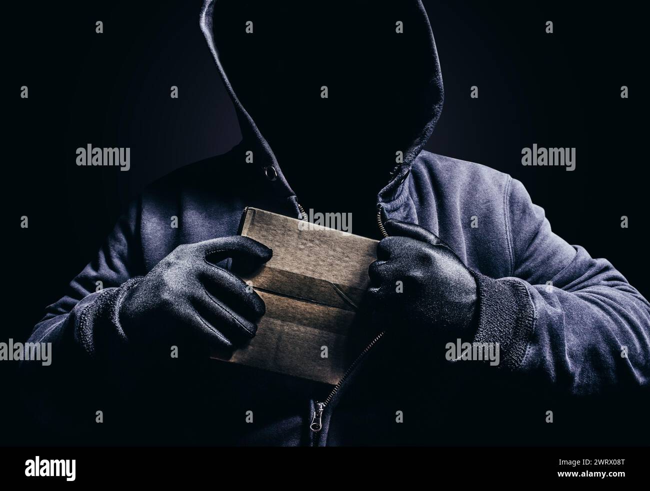 Photo of scary shaded hooded man hiding cardboard box parcel on dark ...