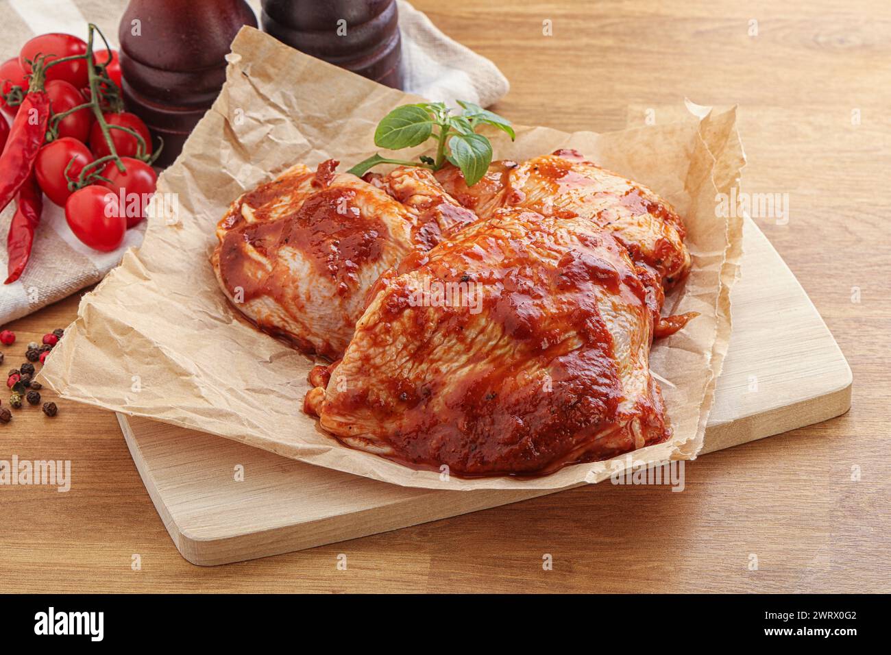 Marinated chicken leg thighs in tomato sauce Stock Photo - Alamy