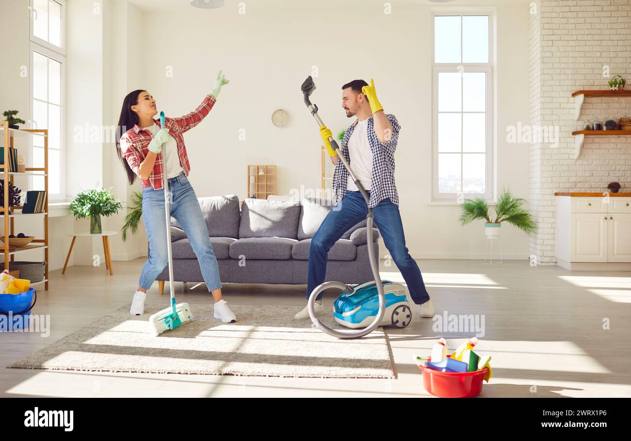 Funny couple cleaning home together having fun, dancing at home while ...