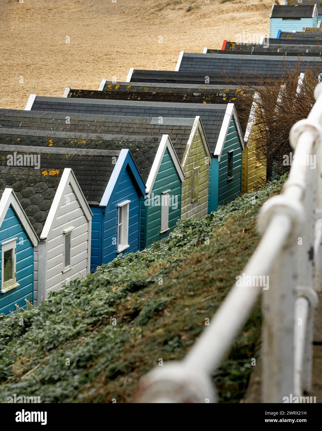 Row of coloured wooden beach huts from pathway hi-res stock photography ...