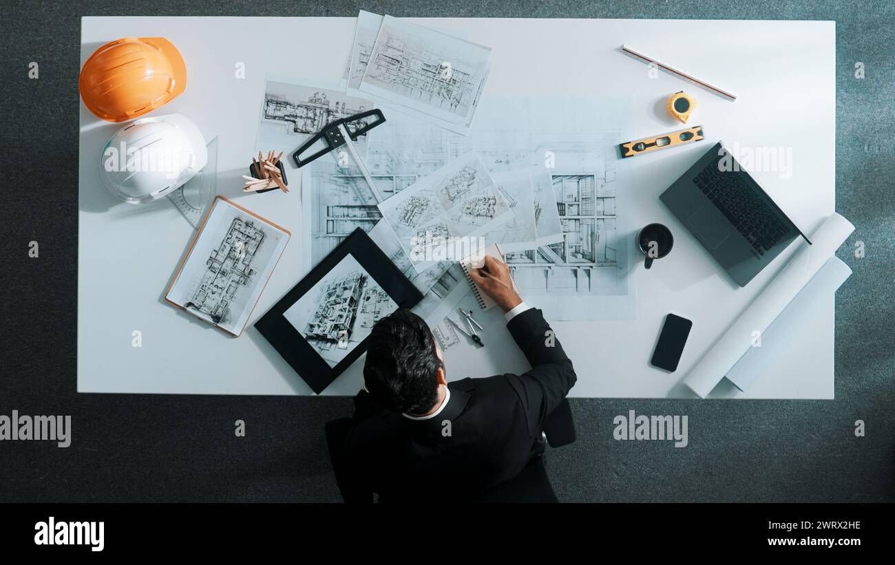Top view of skilled engineer selecting material for house design while ...
