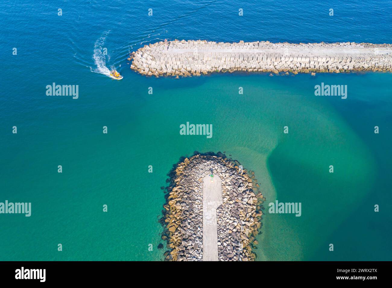 ship entering a port protected by breakwaters, view from a drone Stock ...