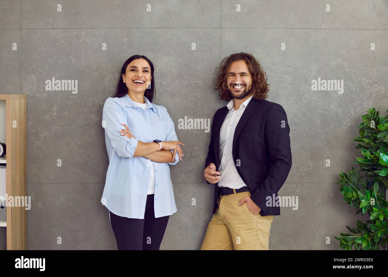 Team of two happy business people, colleagues and friends standing by ...