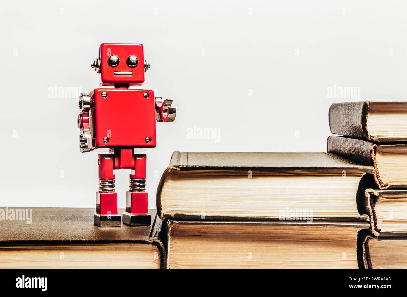 Photo of old antique books stack with red robot toy standing on it on ...