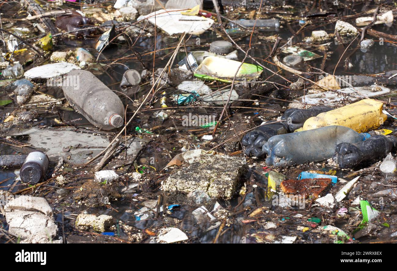 Garbage is lying together in the river, on the outdoors. Removal ...