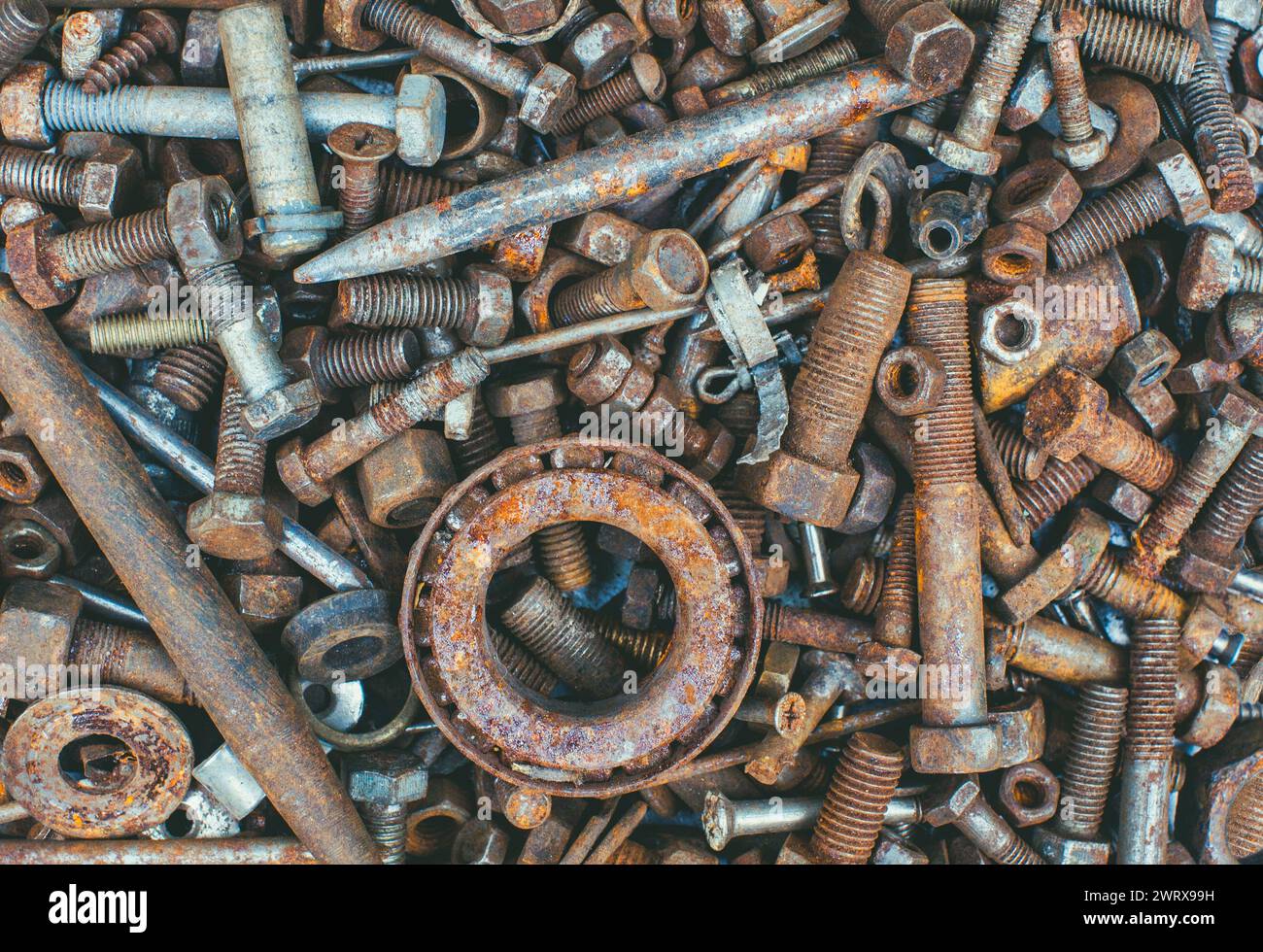 Old rusty worn metal details- bolts nuts bearings chain lie in a heap ...
