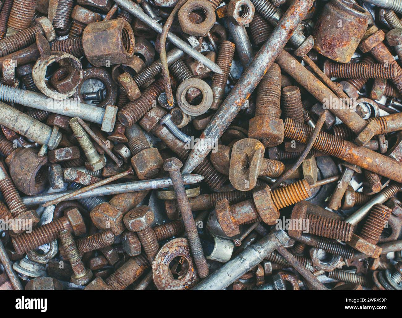Old rusty worn metal details- bolts nuts bearings chain lie in a heap ...