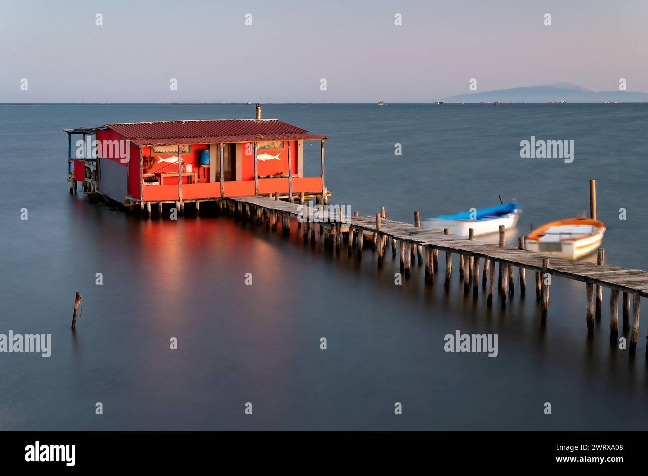 Traditional wooden house of fisherman and boats at dawn at the Axios ...