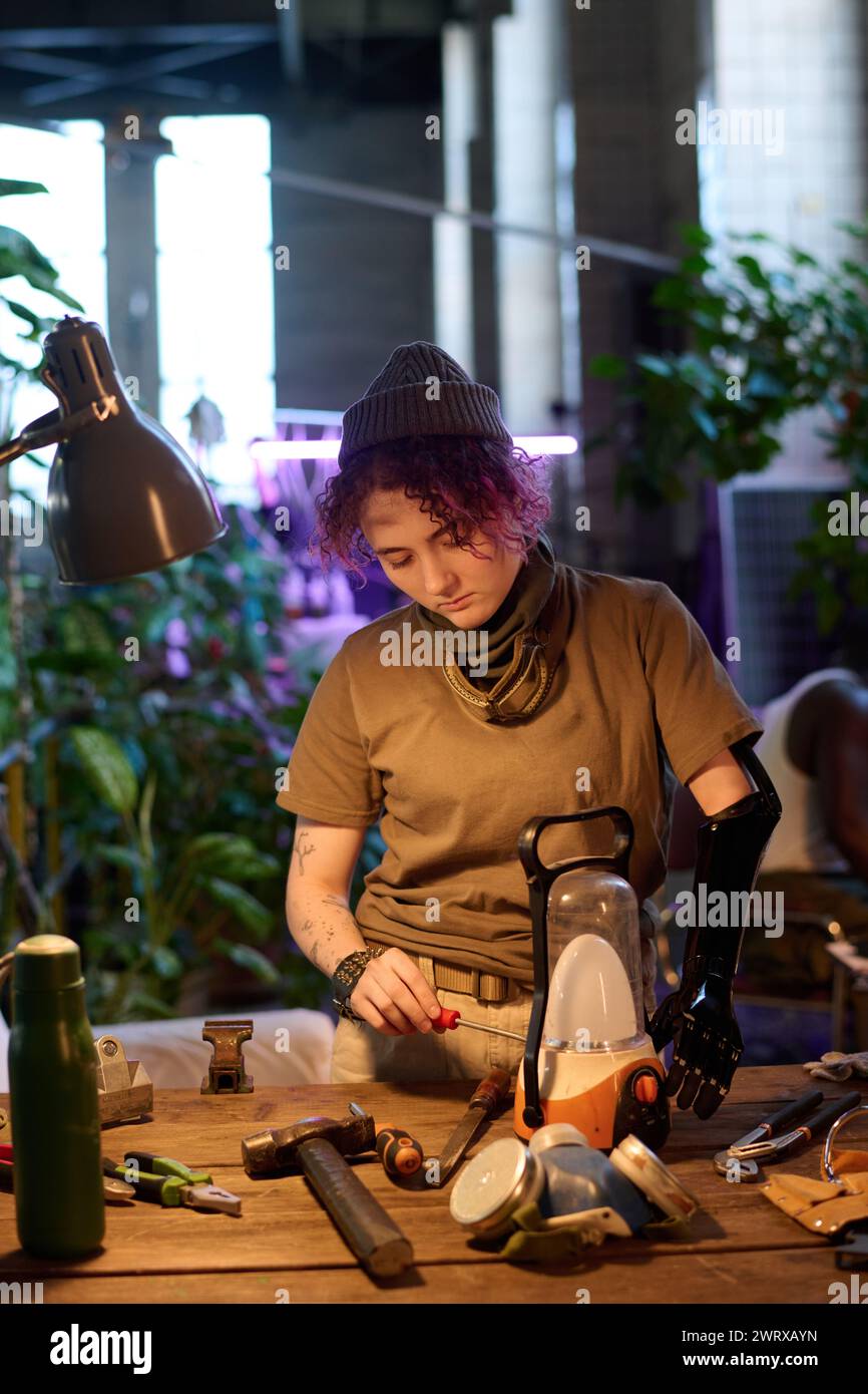 Vertical medium shot of young Caucasian woman with prosthetic arm ...