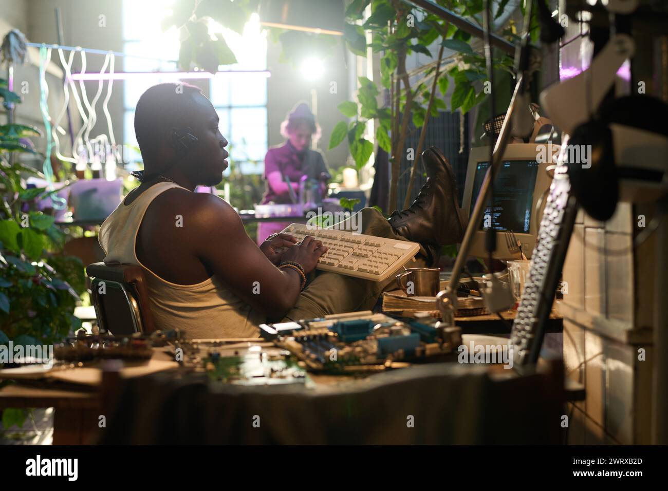 Selective focus shot of African American hacker coding on old desktop ...