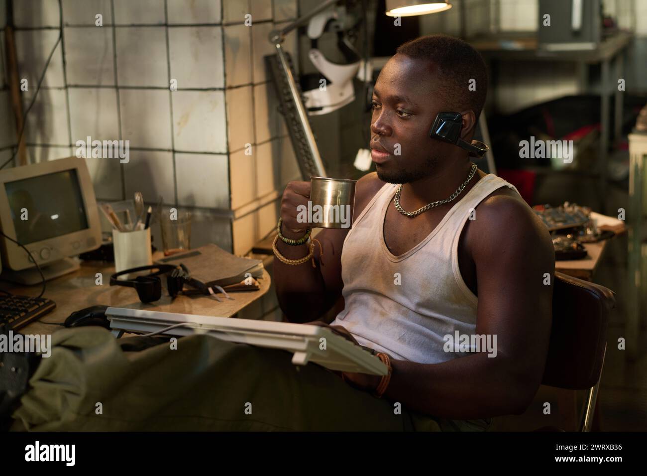 Medium shot of young African American programmer sitting at workplace ...