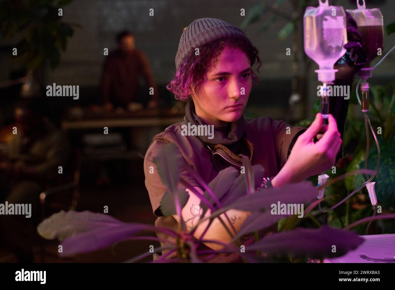 Medium shot of young Caucasian woman living in post-apocalyptic shelter ...