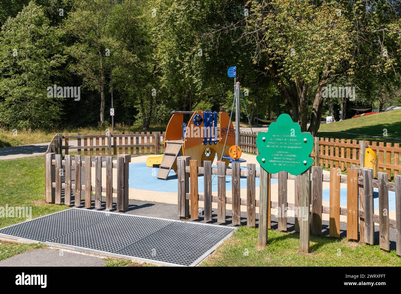 Children playground with wooden railing and toys in a public park with ...