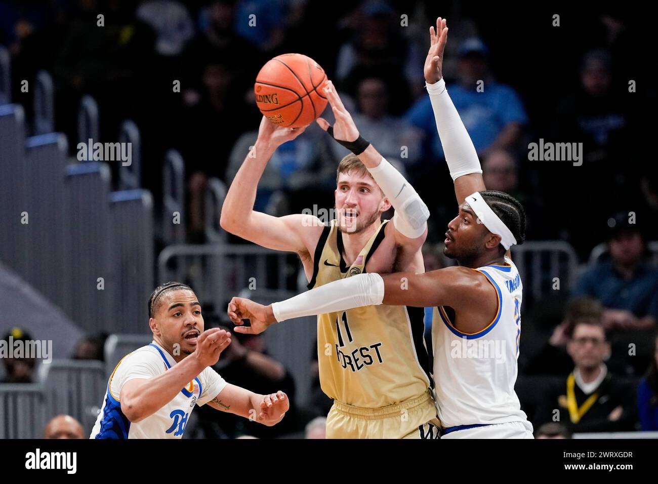 Wake Forest forward Andrew Carr, center, is trapped by Pittsburgh guard ...