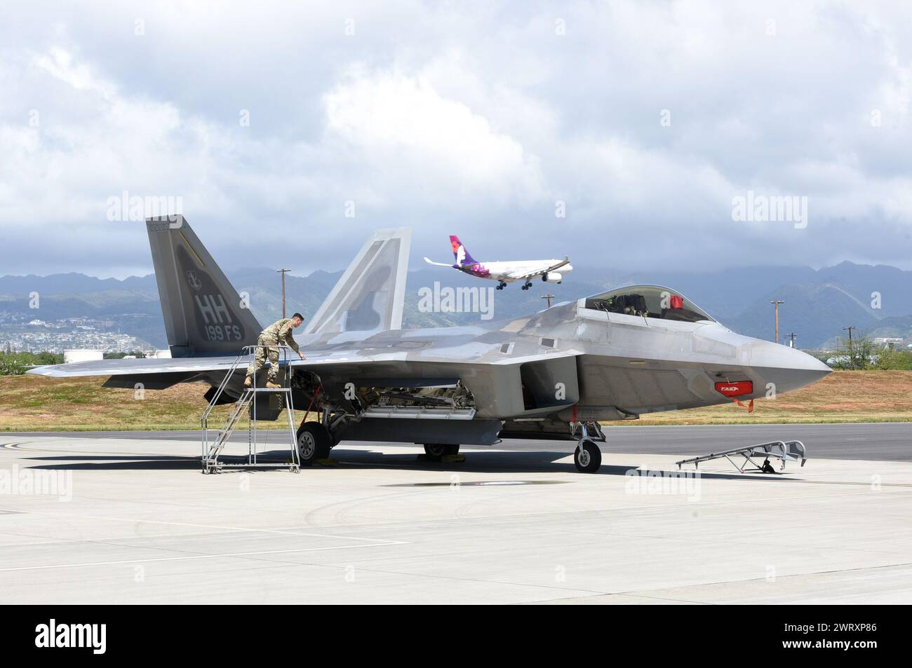 An F-22 Raptor maintainer services a Hawaii Air National Guard F-22 ...