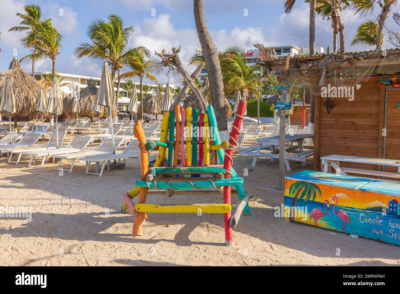A close-up view of the sandy beach with a large decorative chair made ...