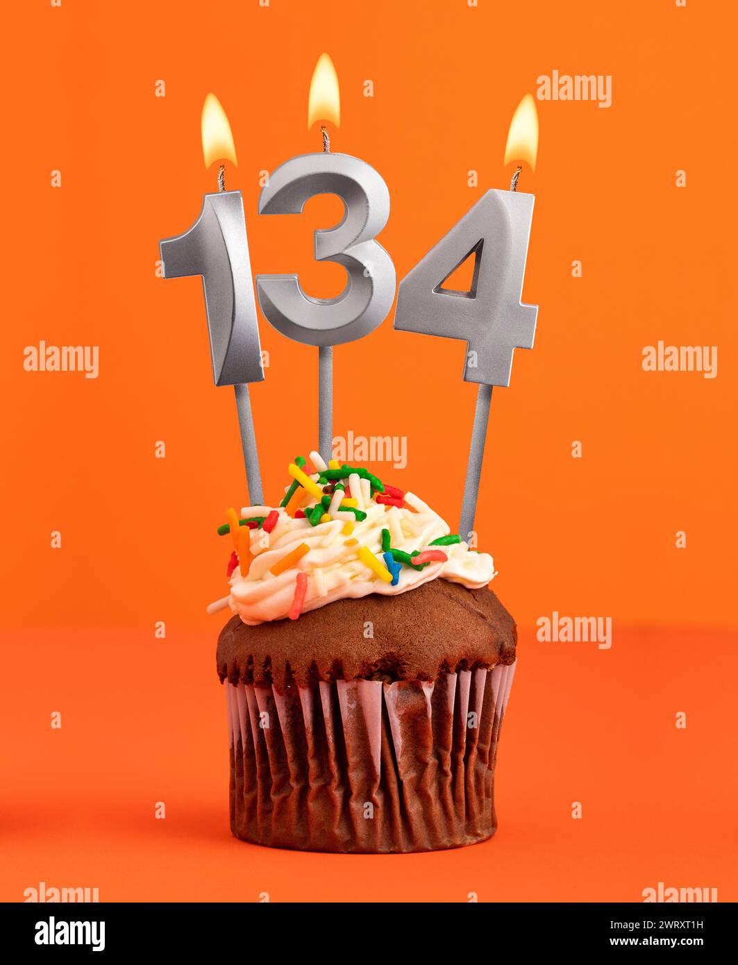 Birthday cupcake with number 134 candle - Orange color background Stock ...