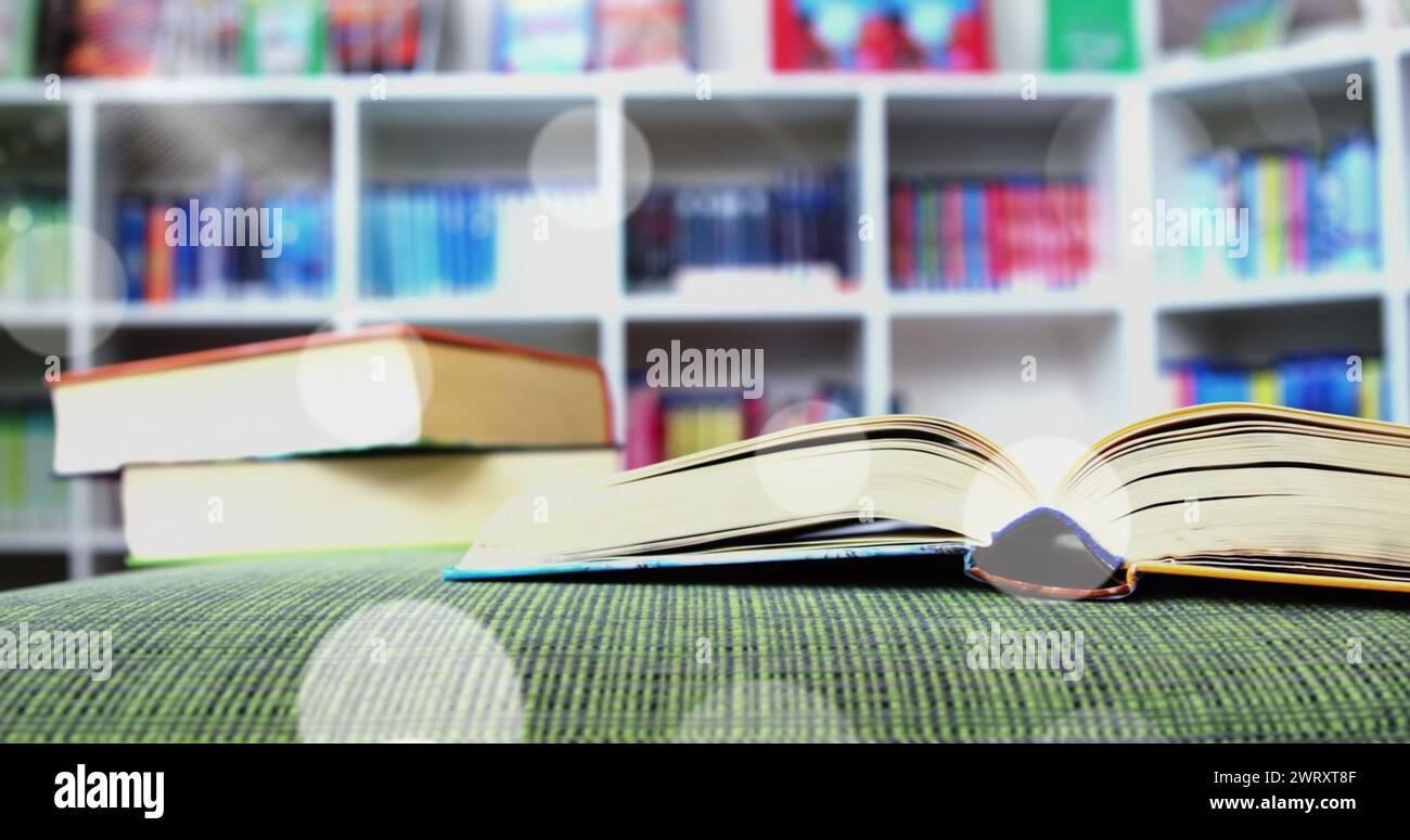 Image of glowing spots of light over books in library Stock Photo - Alamy