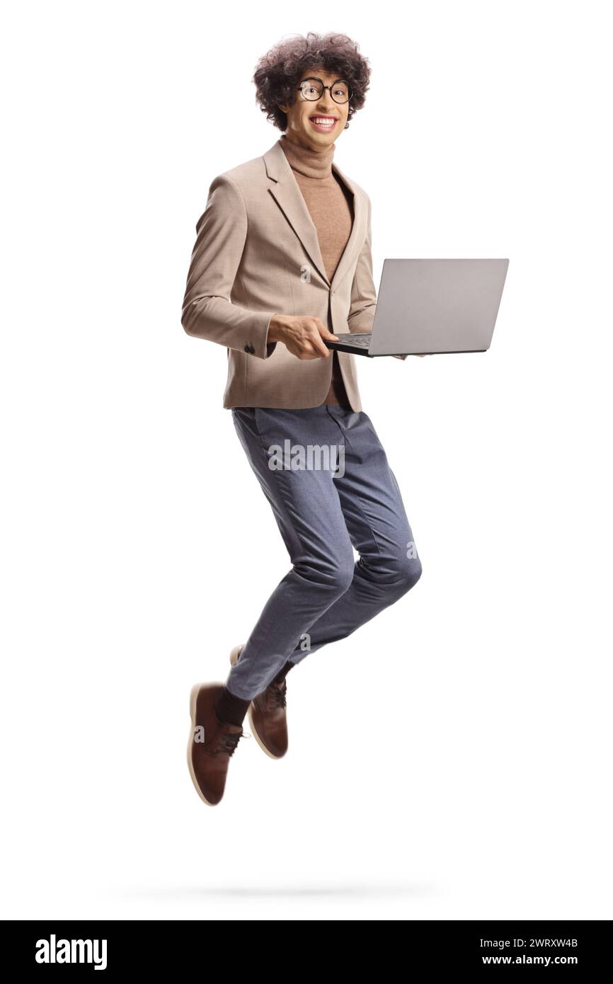 Excited young man holding a laptop computer and jumping isolated on ...
