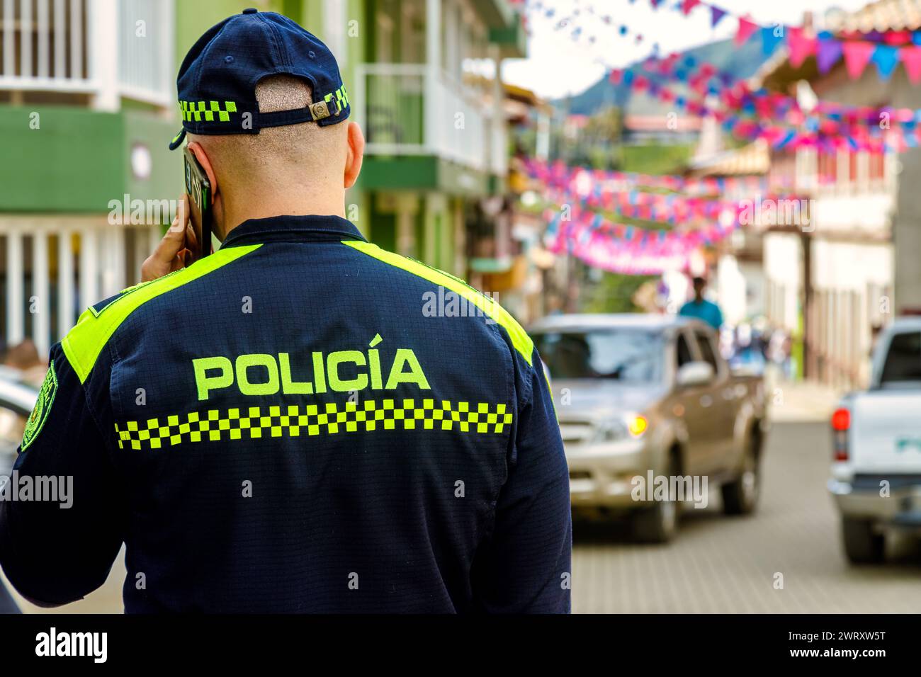 Colombian police officer seen from behind while talking on the phone ...