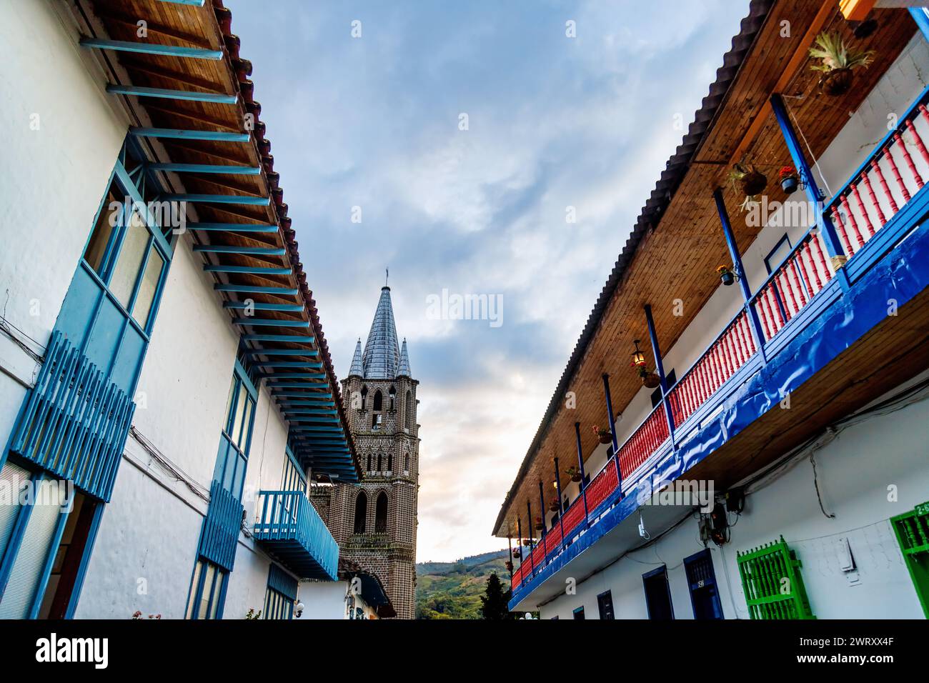 Church tower in the background of a street with colorful balconies in ...