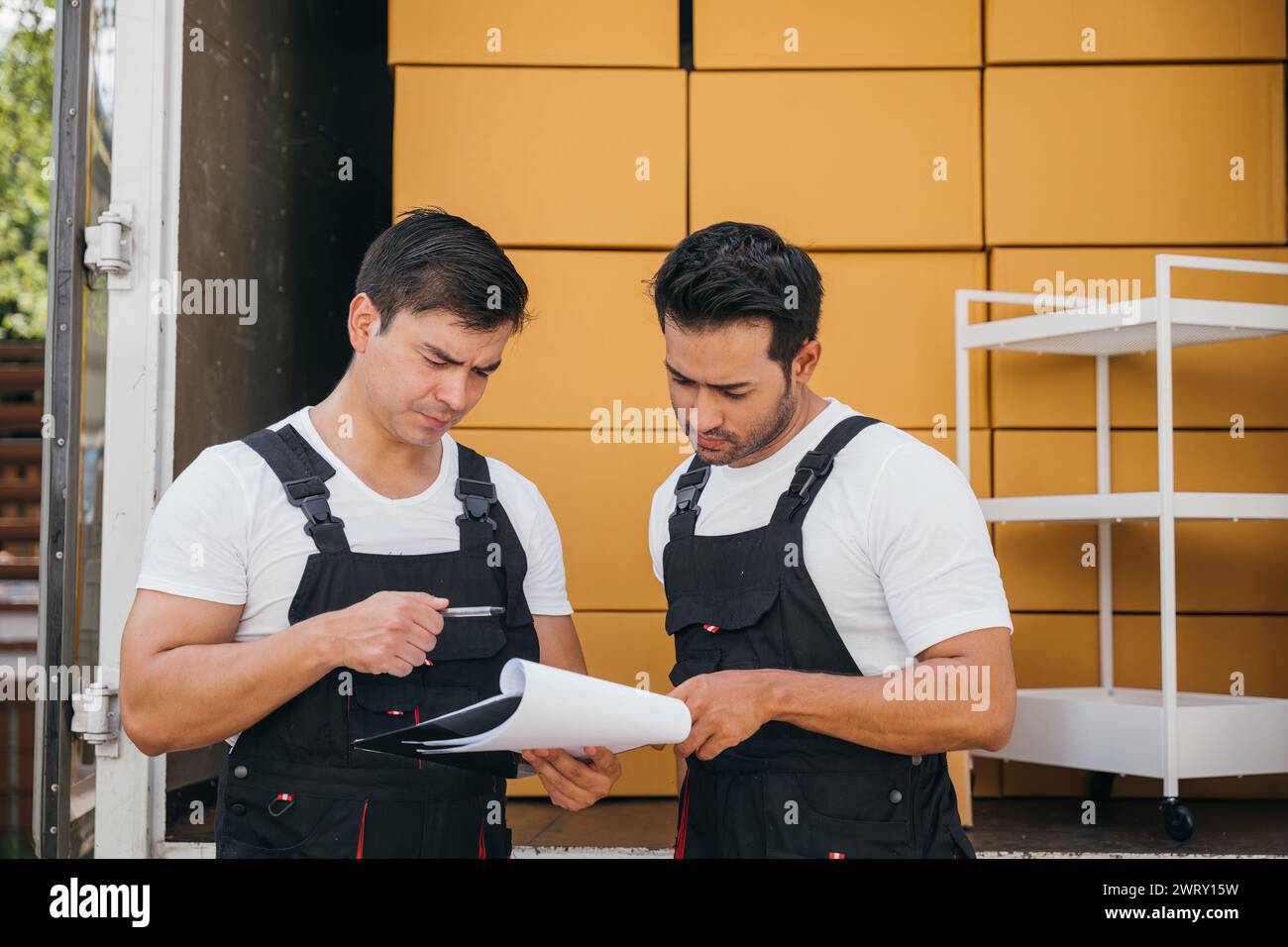 Teamwork outdoors, workers unload boxes checking documents for the ...