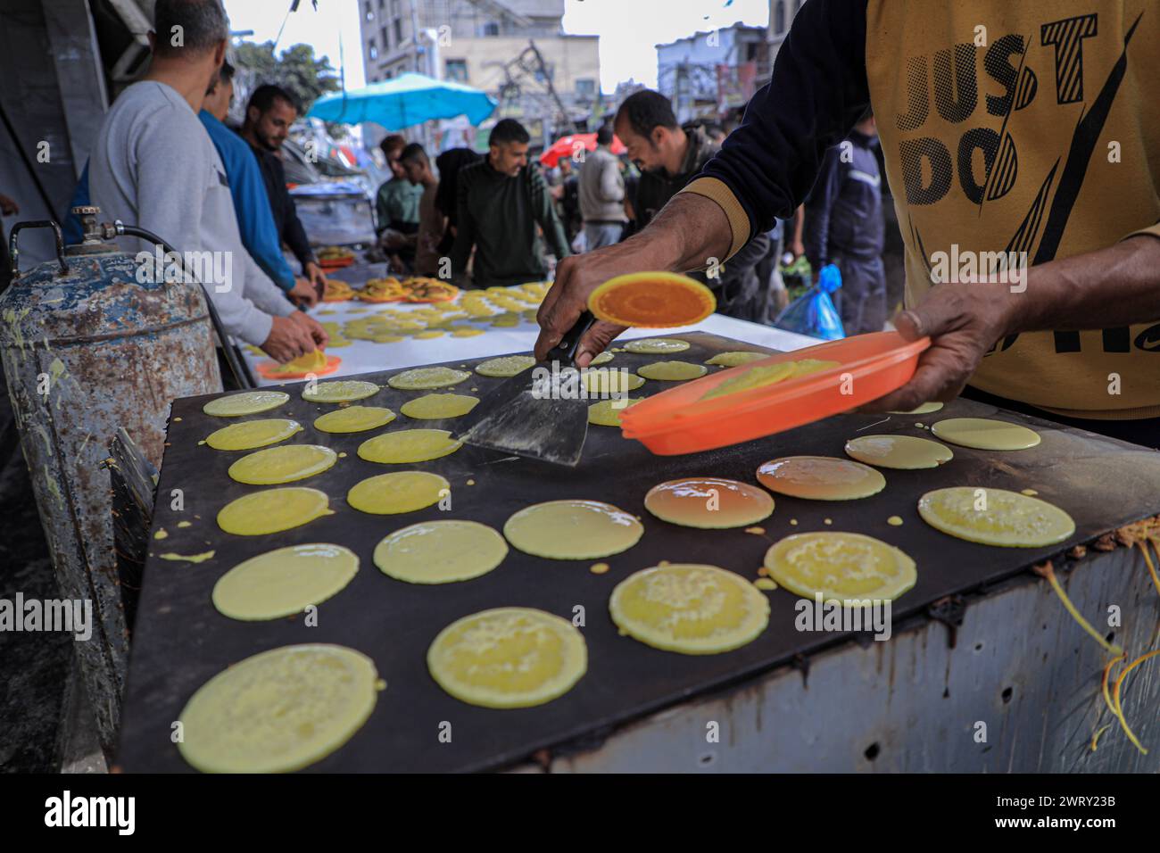 Gaza. 14th Mar, 2024. People make traditional sweets at a market during ...