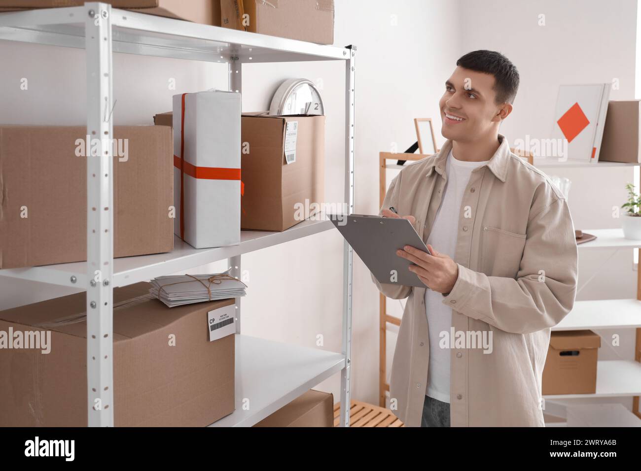 Male online store seller with clipboard working in warehouse Stock ...