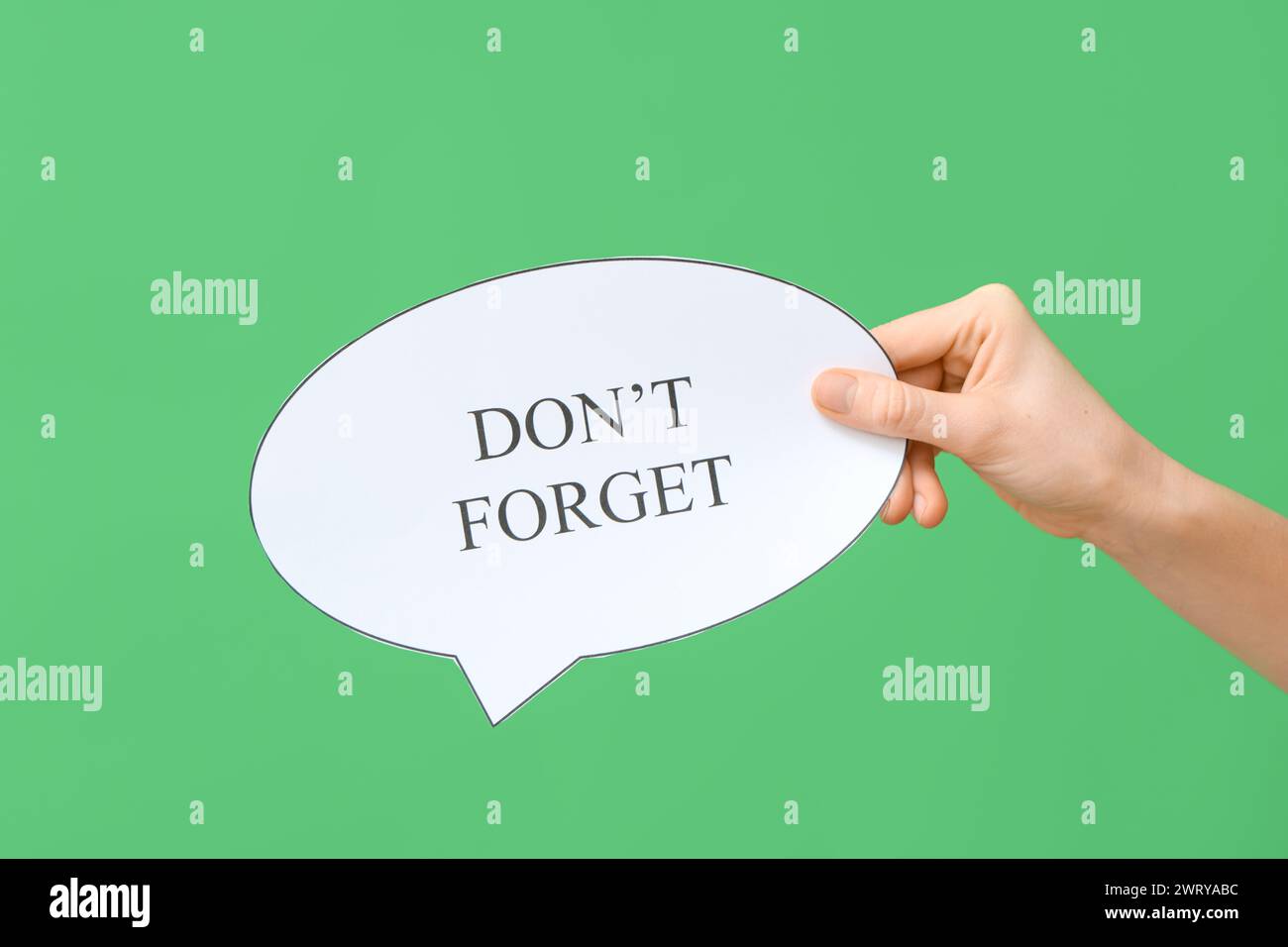 Female hand holding speech bubble with text DON'T FORGET on green ...