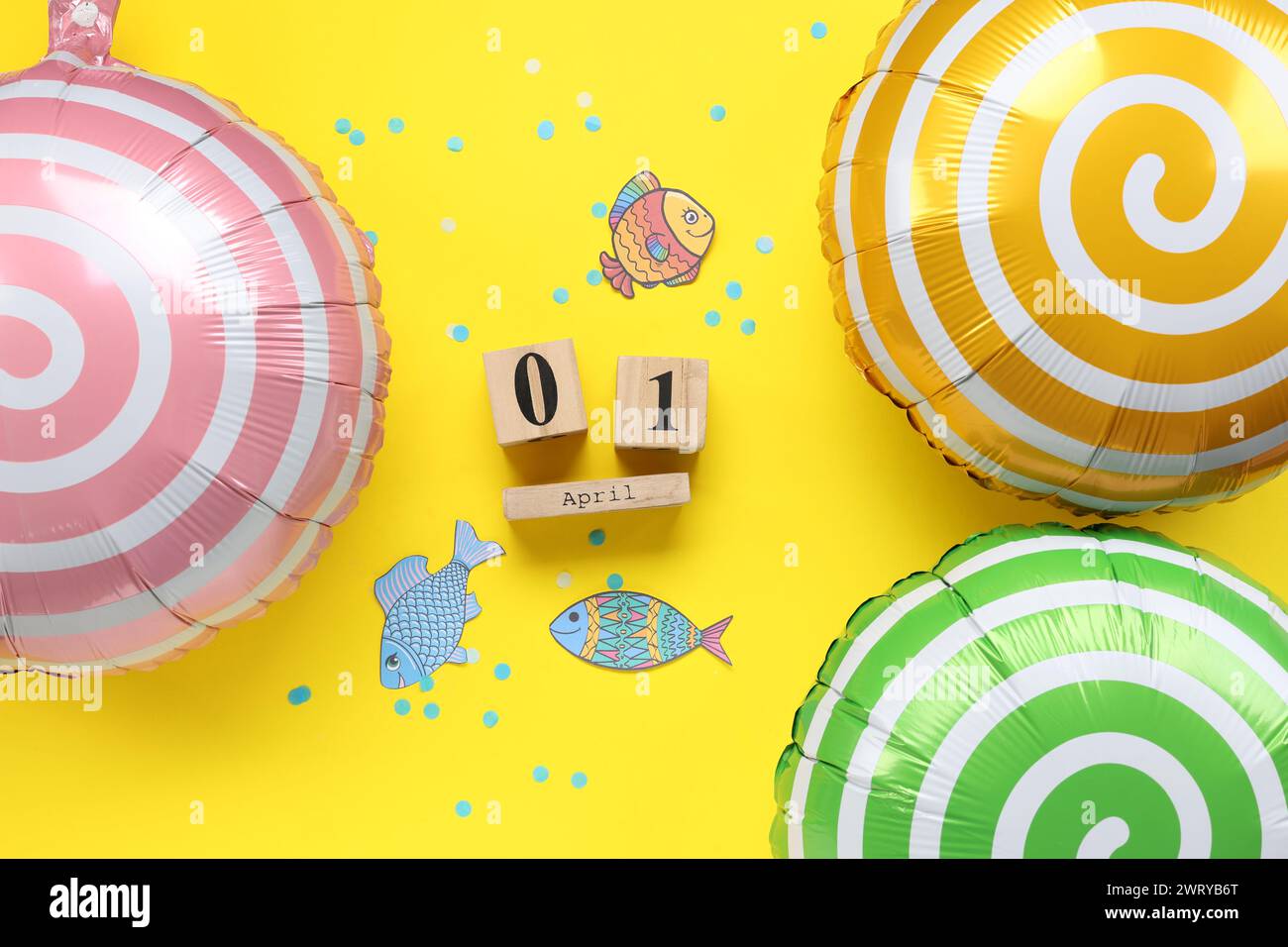 Calendar with balloons, paper fishes and confetti on yellow background ...