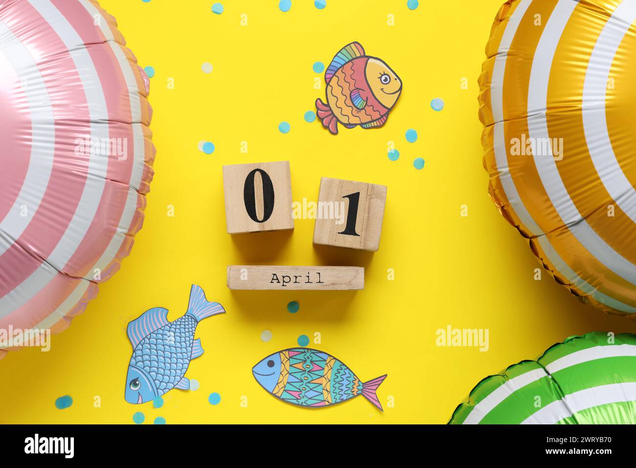 Calendar with balloons, paper fishes and confetti on yellow background ...