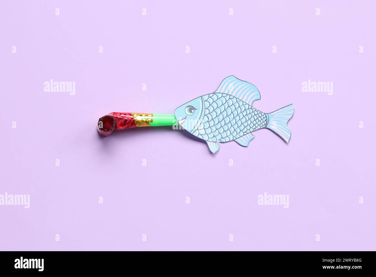 Paper fish with party whistle on lilac background. April Fools Day ...