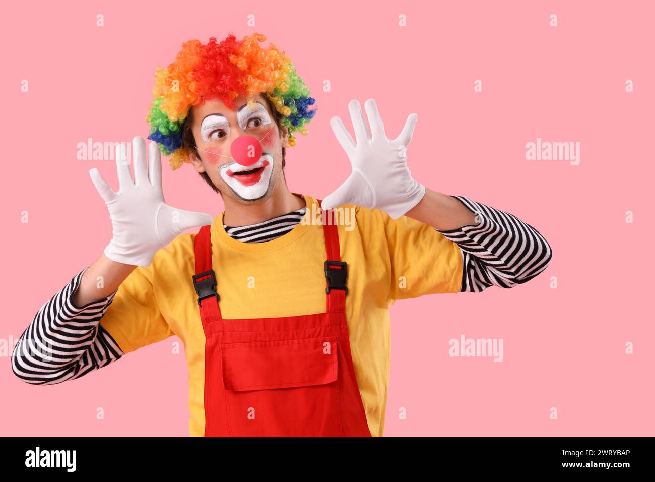 Portrait of surprised clown on pink background. April Fool's day ...