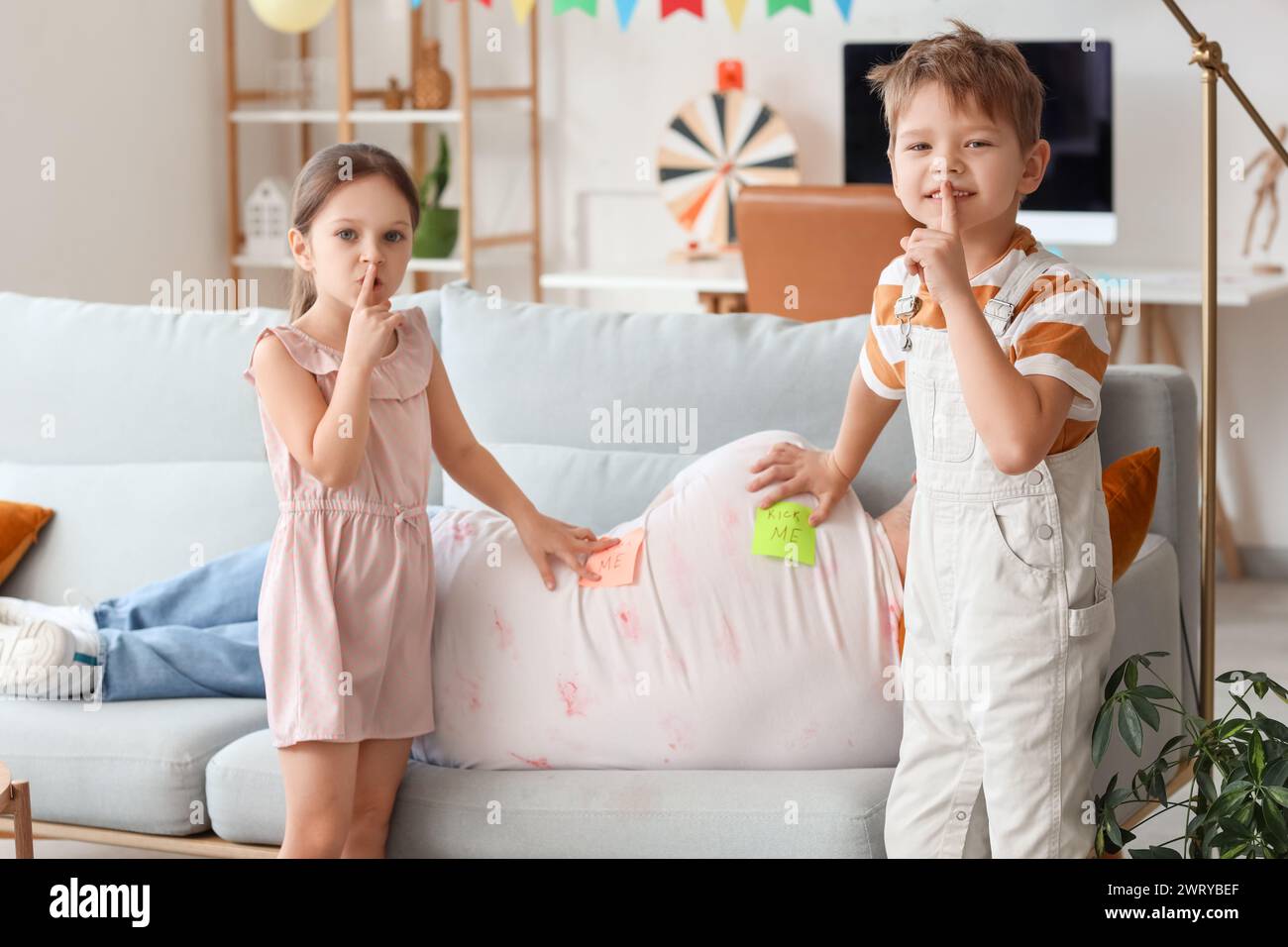 Little children sticking KICK ME stickers to their sleeping father's ...