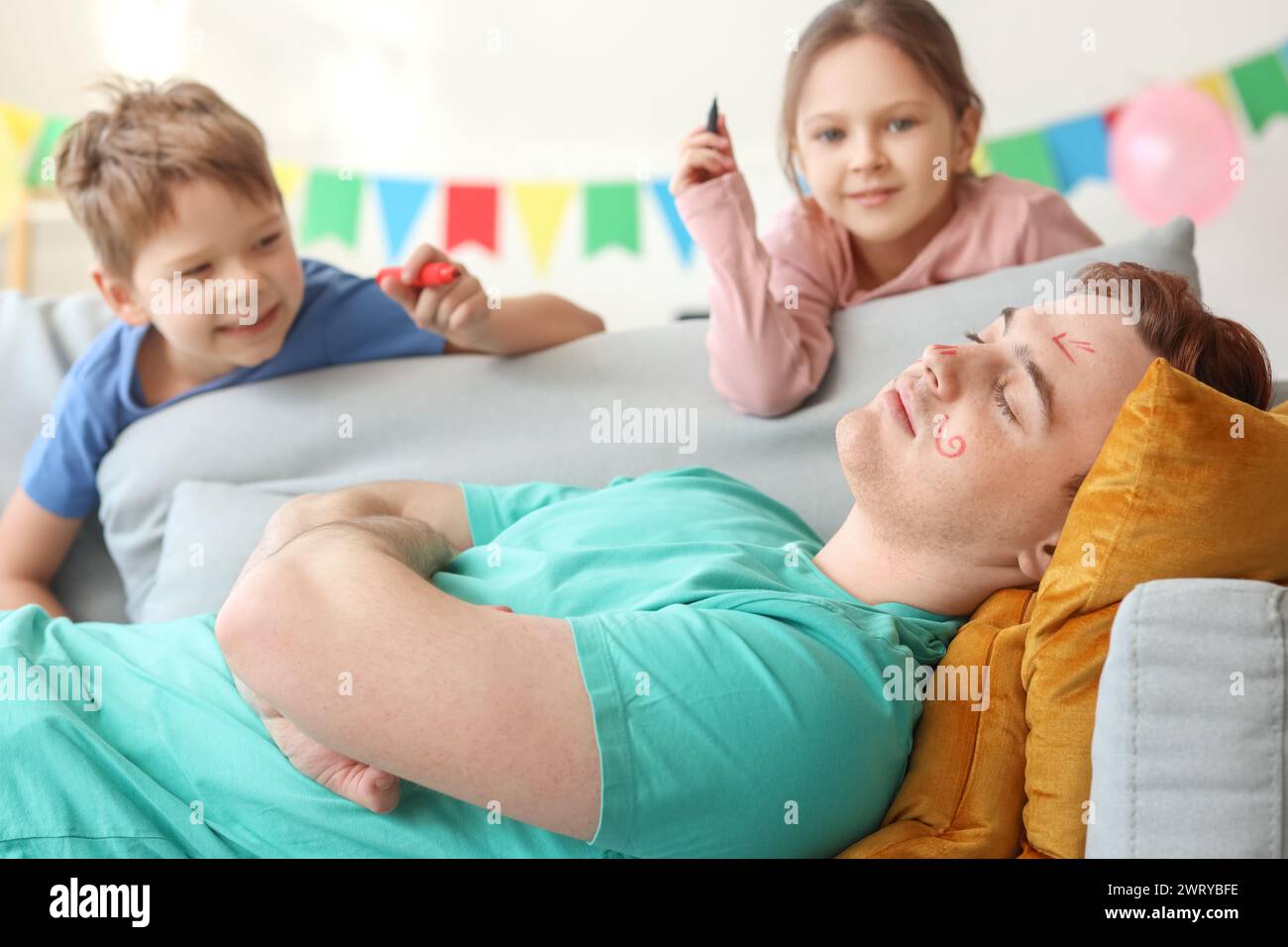 Little children painting face of their sleeping father at home. April ...