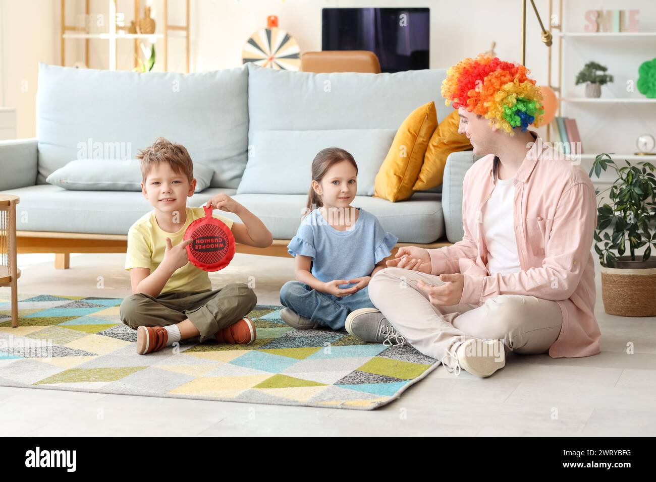 Father in colorful clown wig and his children with whoopee cushion at ...