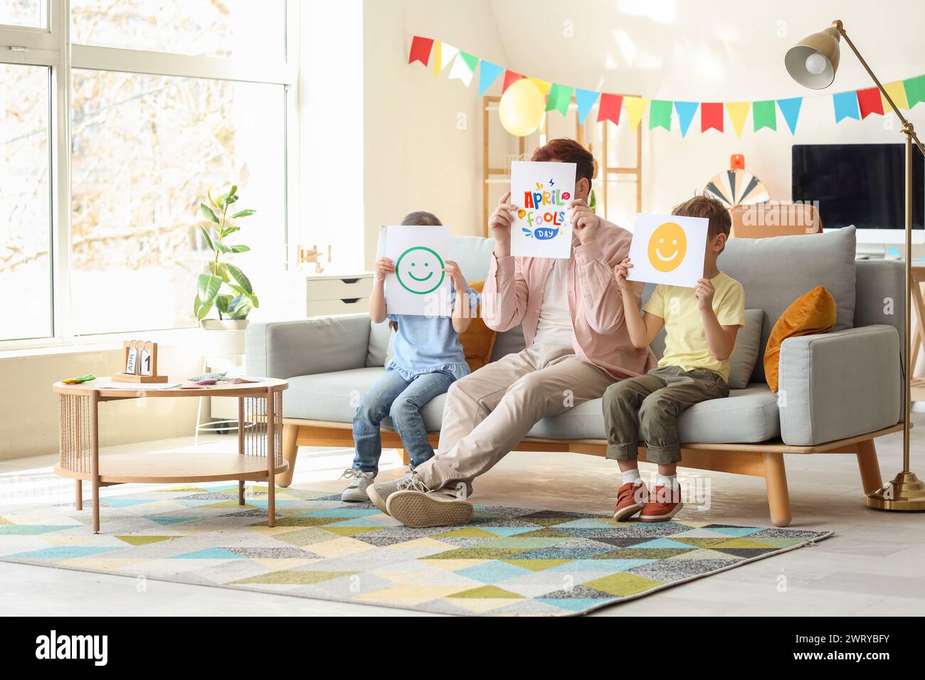 Father and his children with April Fool's Day posters at home Stock ...