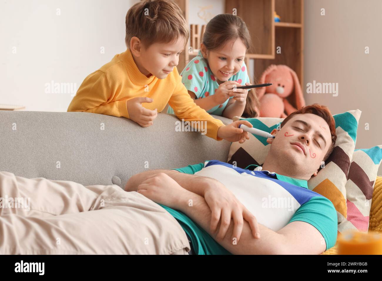 Little children painting face of their sleeping father at home. April ...