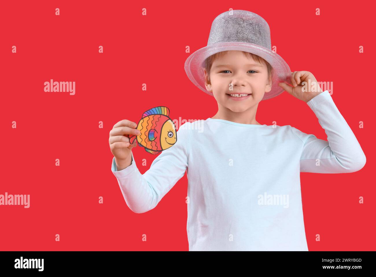 Cute little boy in party hat with paper fish on red background. April ...