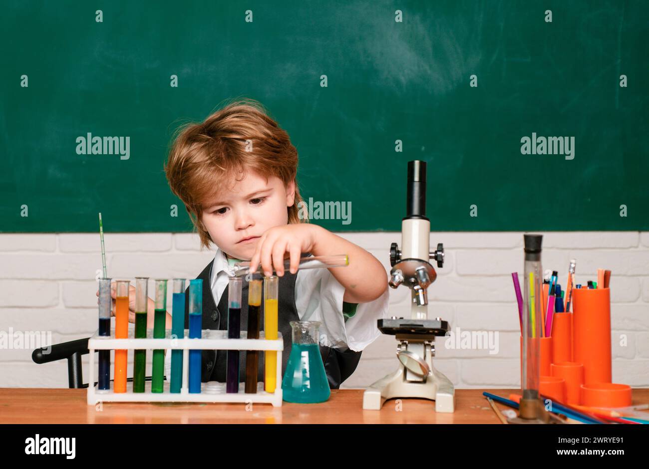 Cheerful smiling little boy having fun against blue wall. First grade ...