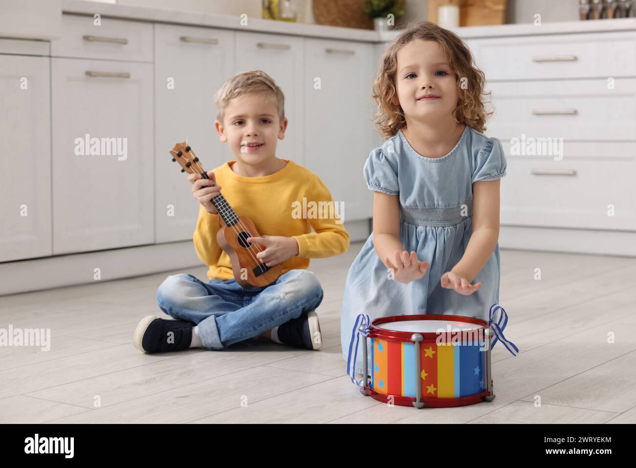 Little children playing toy musical instruments in kitchen Stock Photo ...