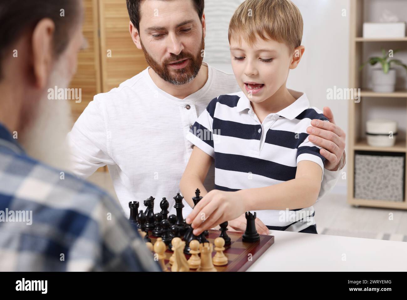 Father grandfather son playing chess hi-res stock photography and ...