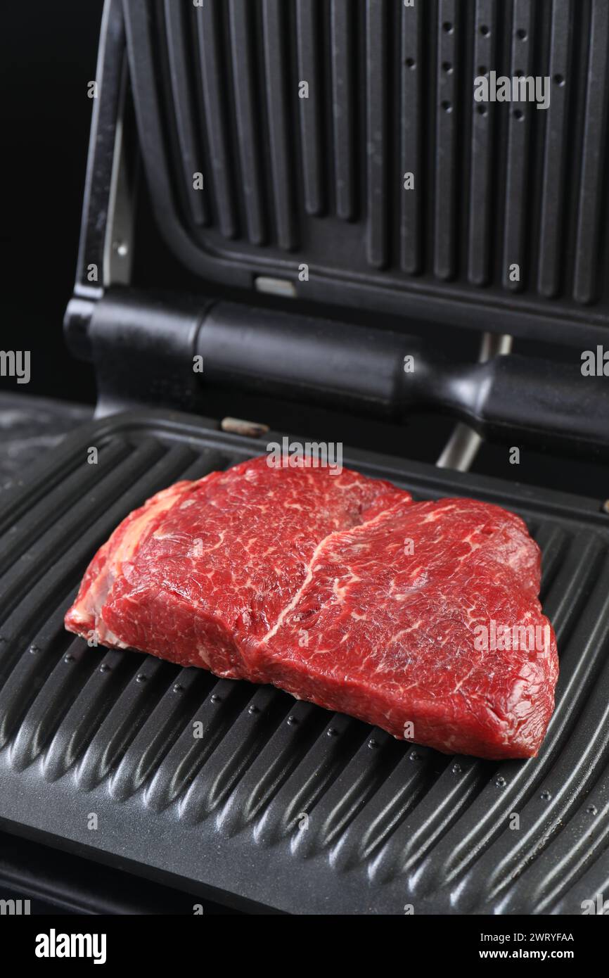 Cooking fresh beef cut on electric grill Stock Photo - Alamy