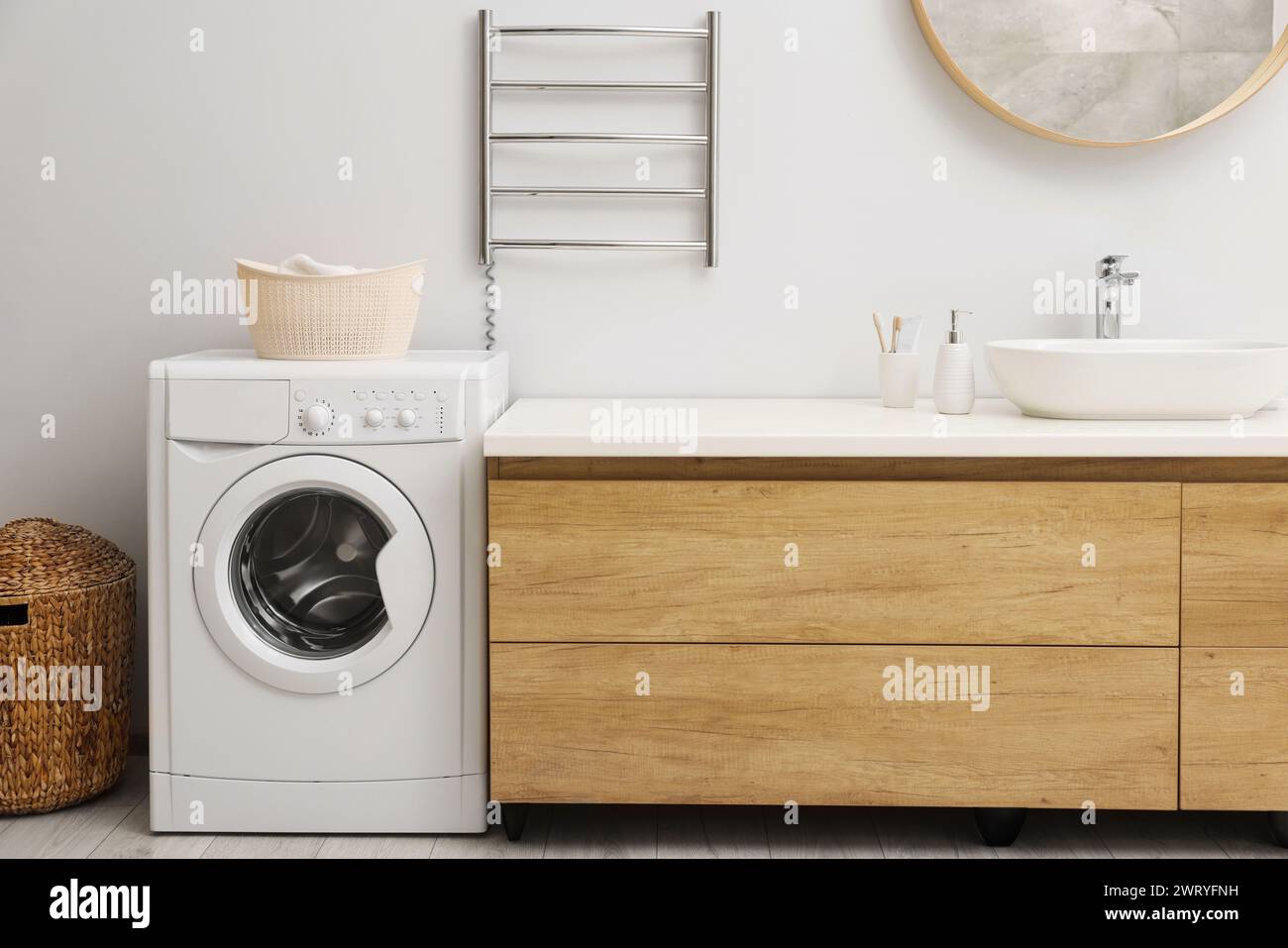 Stylish bathroom interior with heated towel rail and washing machine ...