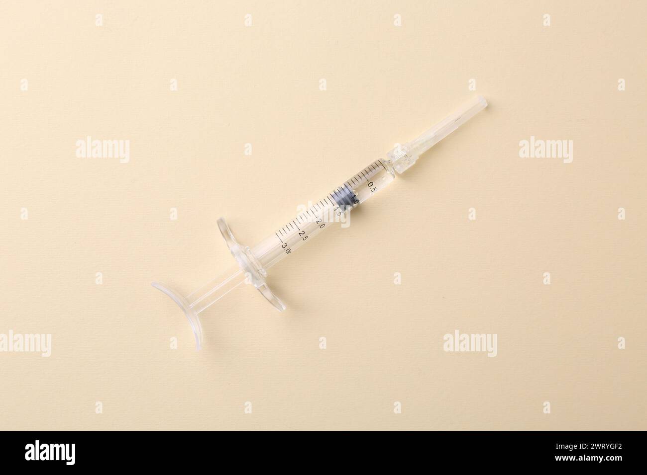 Injection cosmetology. One medical syringe on beige background, top ...