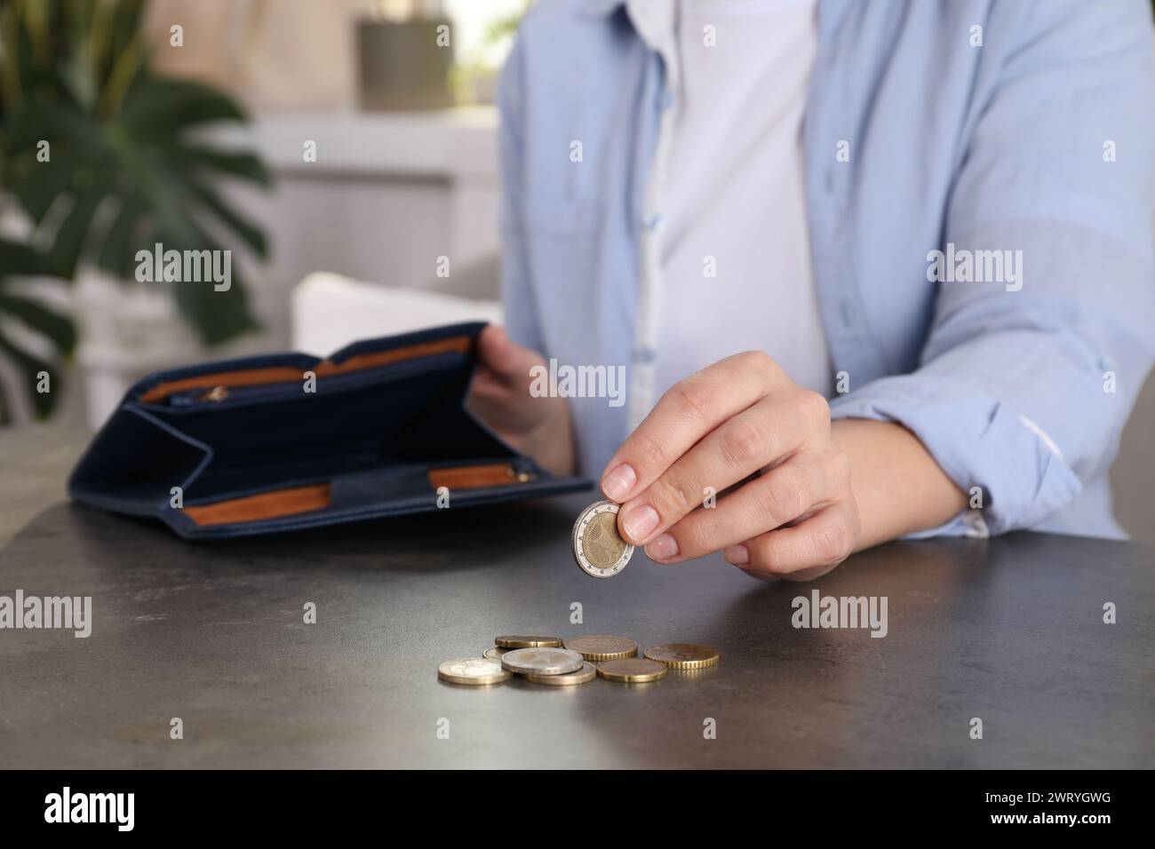 Poor woman counting coins at grey table indoors, closeup Stock Photo ...