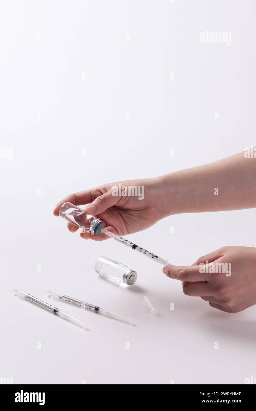 putting a syringe in an injection bottle Stock Photo - Alamy